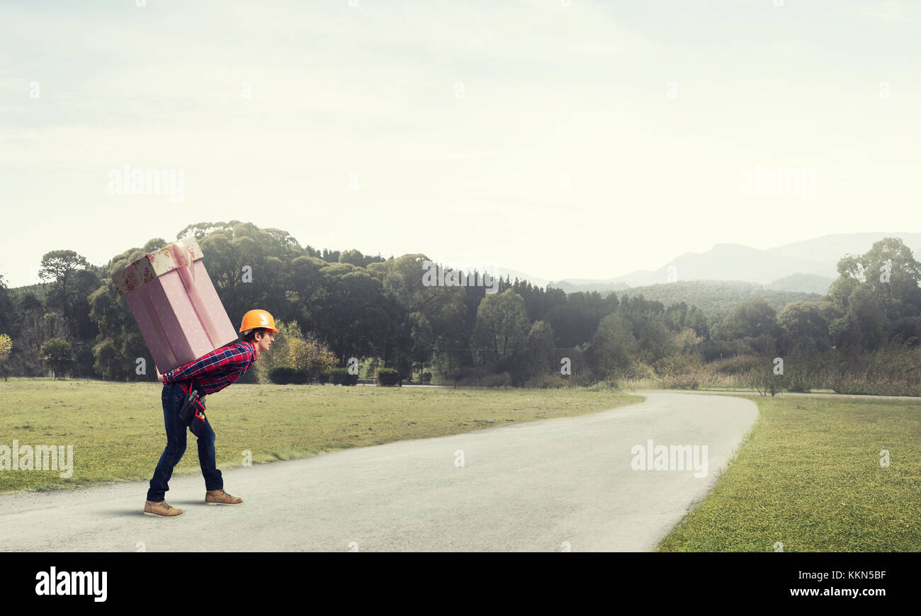 Man carrying on his back large box Stock Photo - Alamy