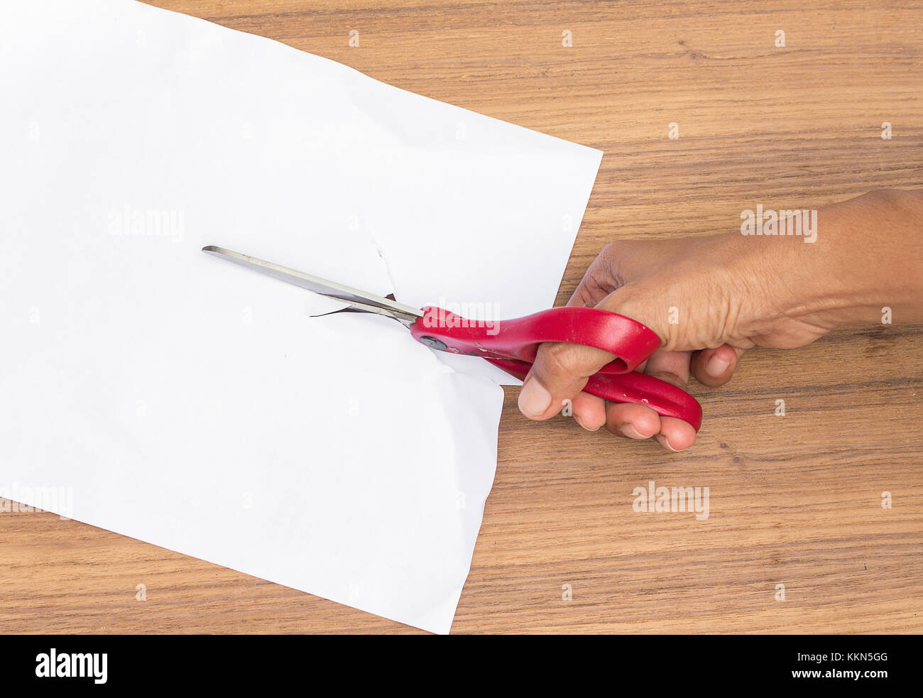 Scissors cut paper, women hand is cutting paper with scissors on a ...