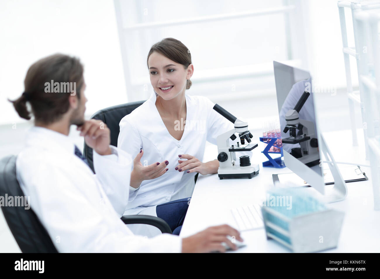 Side view of two scientists conducting a chemical experiment Stock ...