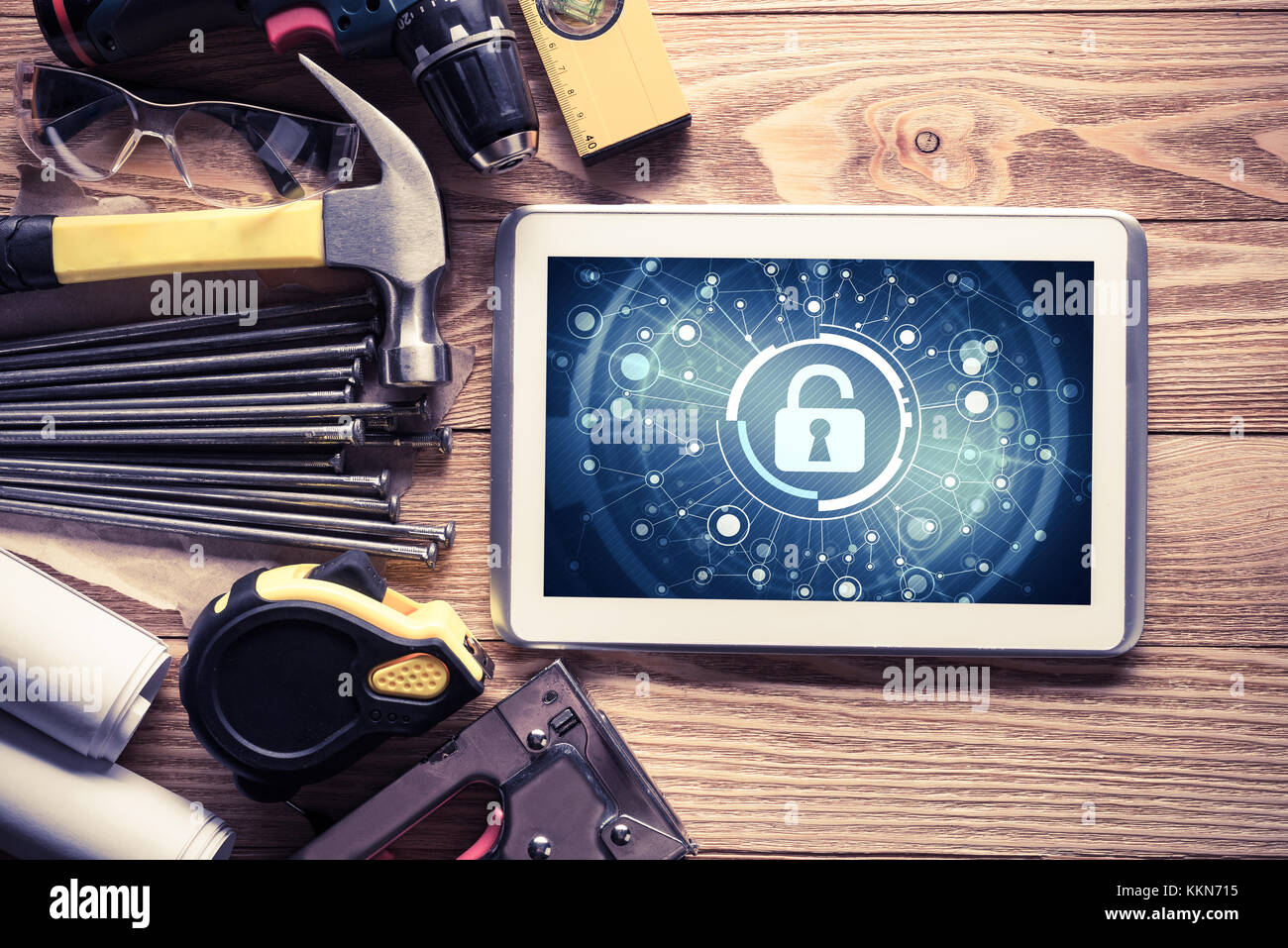 Tablet pc with security concept on screen and industrial tools around ...