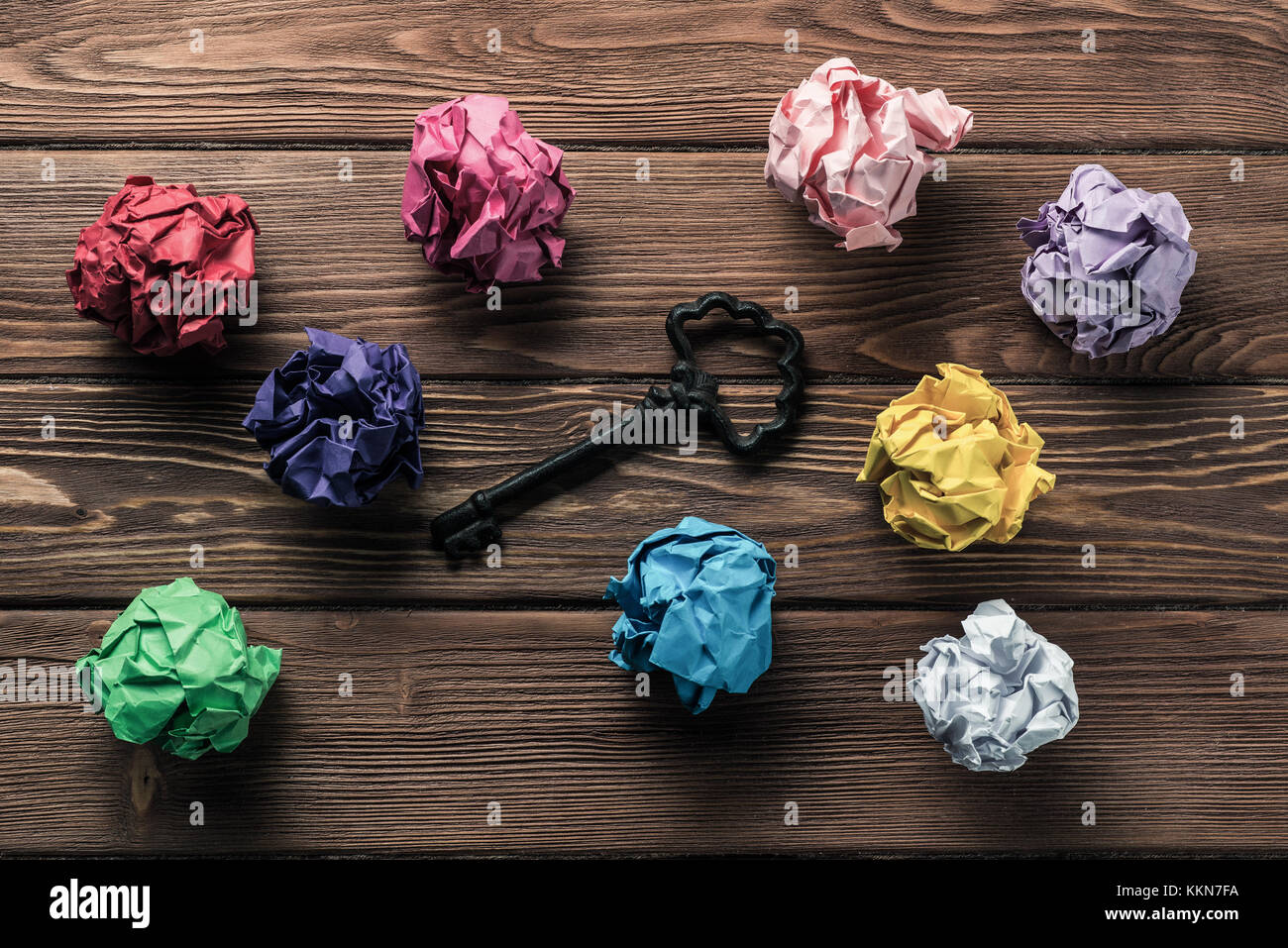 Set of multiple colorful crampled paper ball and key among them, placed ...