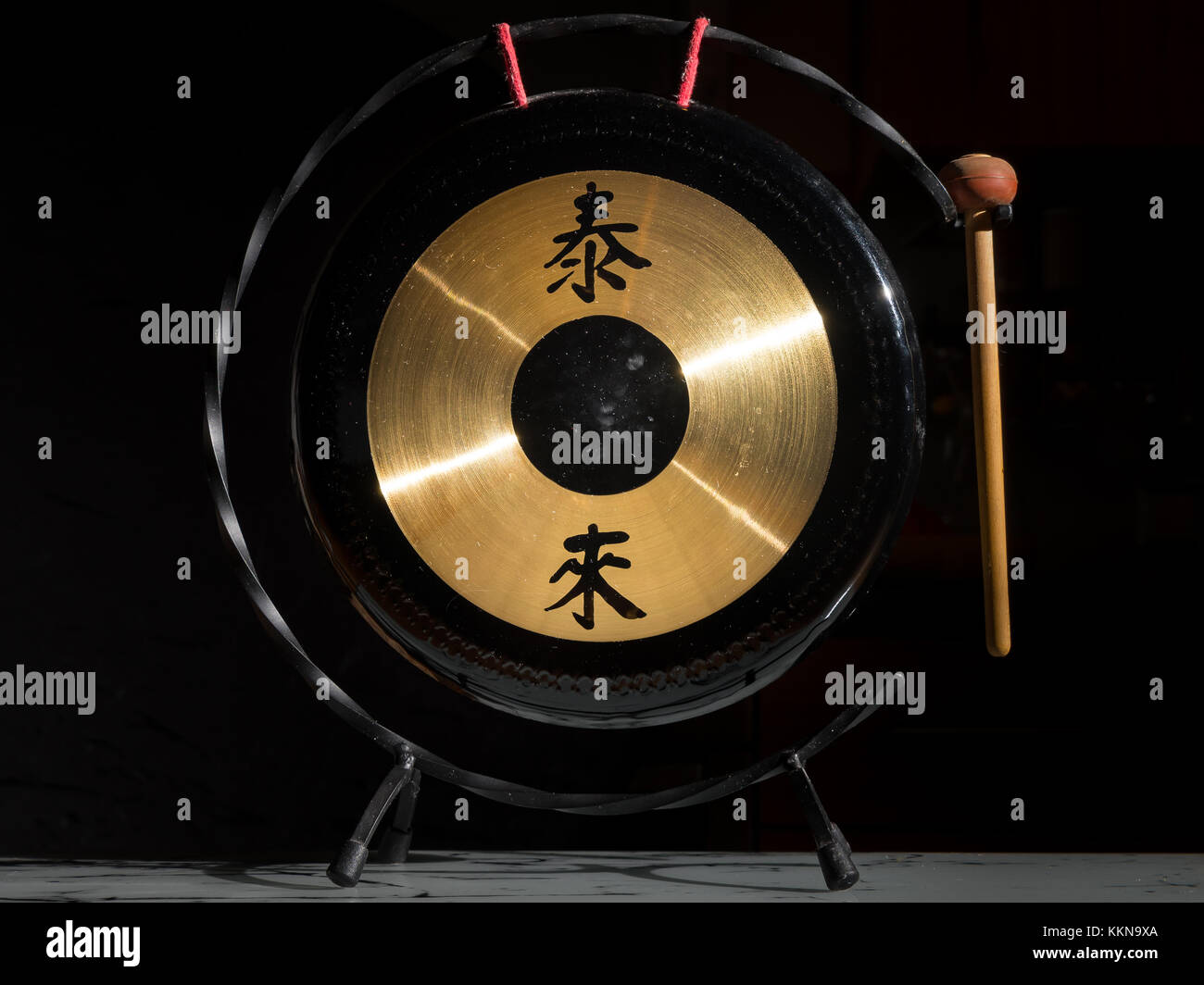 Closeup of a small chinese table gong, black background Stock Photo - Alamy