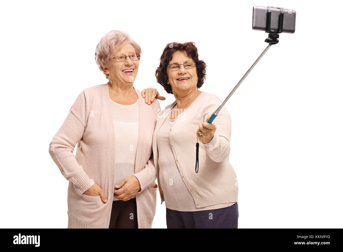 Two Elderly Women Taking A Selfie With A Stick Isolated On White
