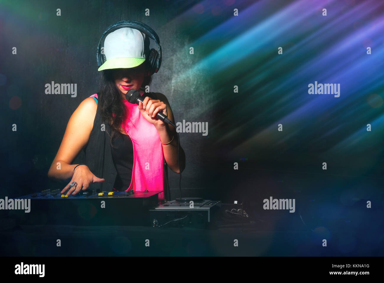 Glamorous girl deejay at work with a microphone mixing sound on her ...