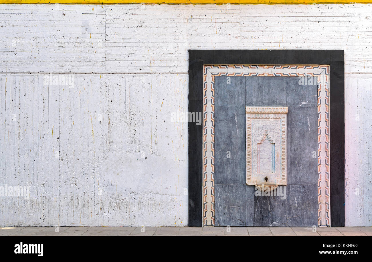 Old white marble water fountain framed by ornate marble frame and black ...