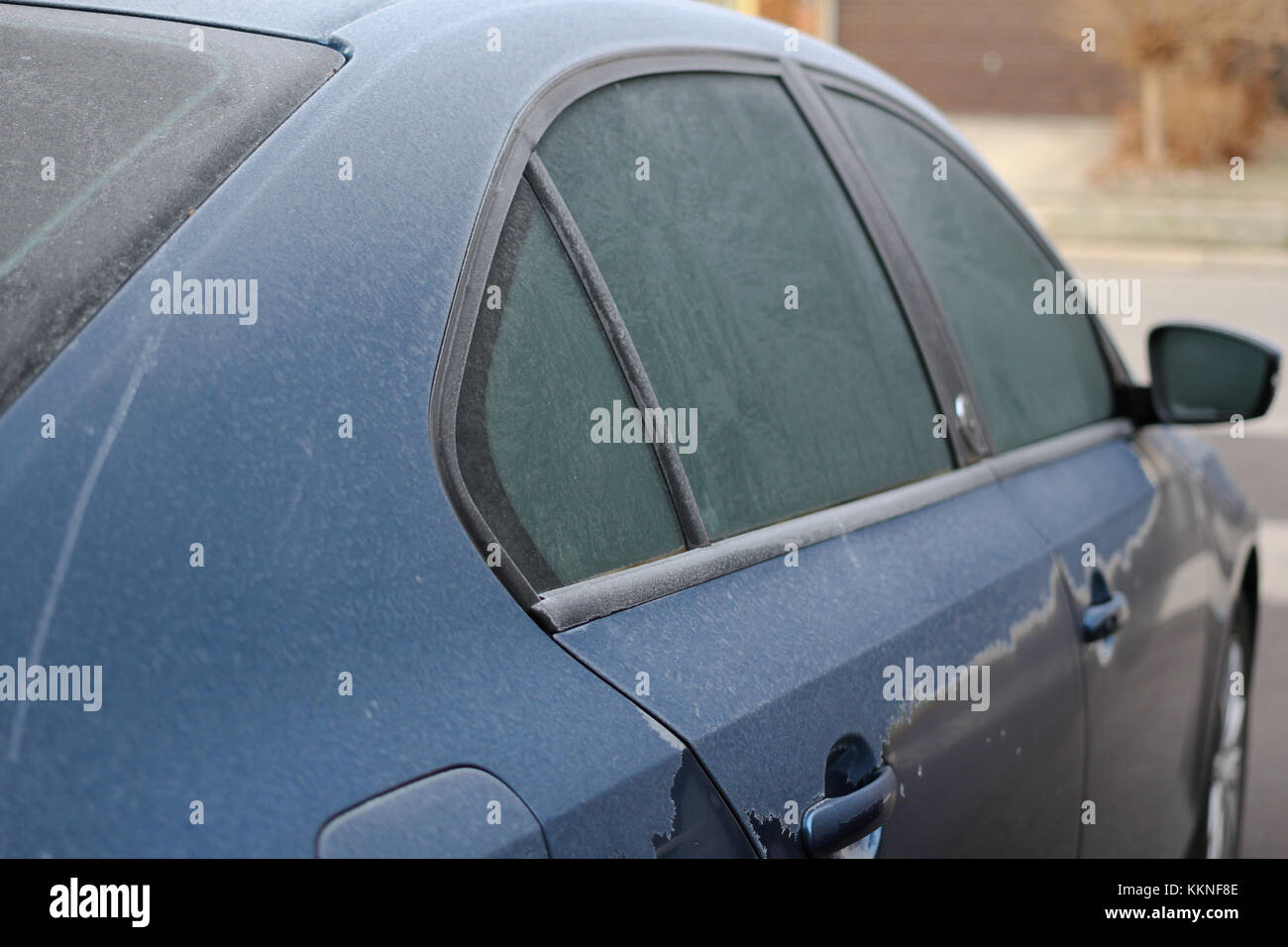 Early morning frost being scraped off the windows and windshield of a ...