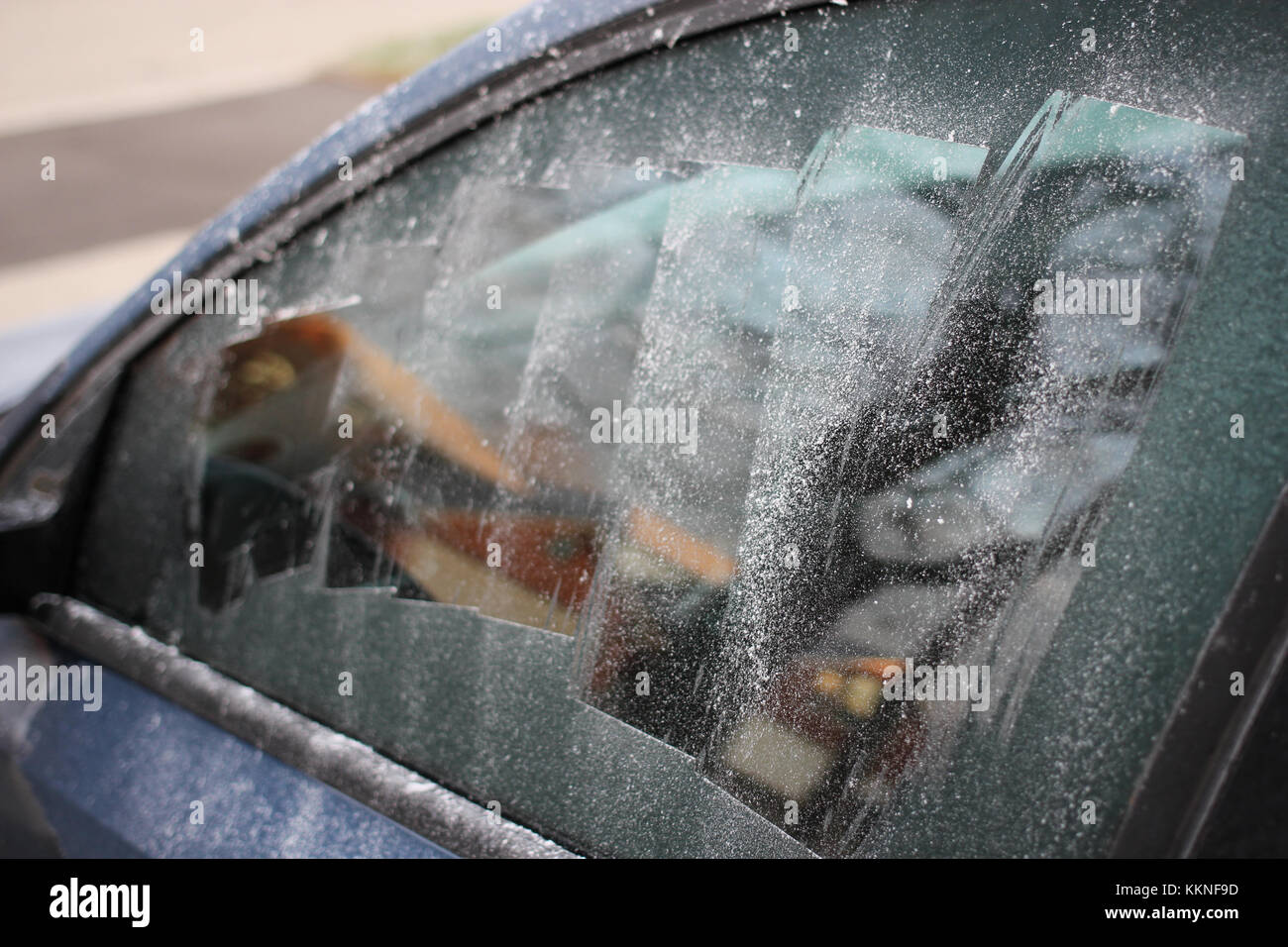 Early morning frost being scraped off the windows and windshield of a ...