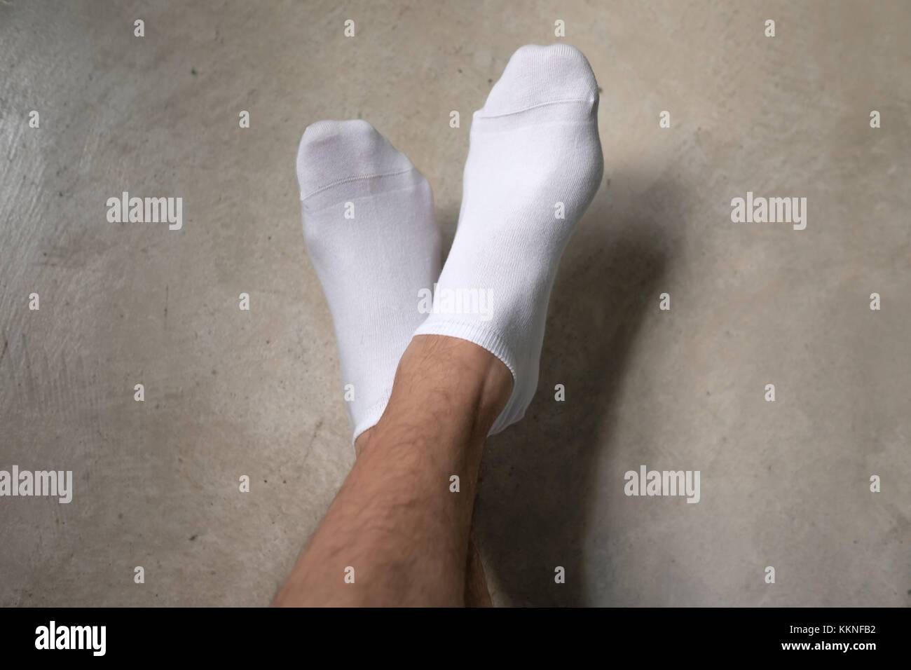 Man wearing socks crossing his legs Stock Photo - Alamy