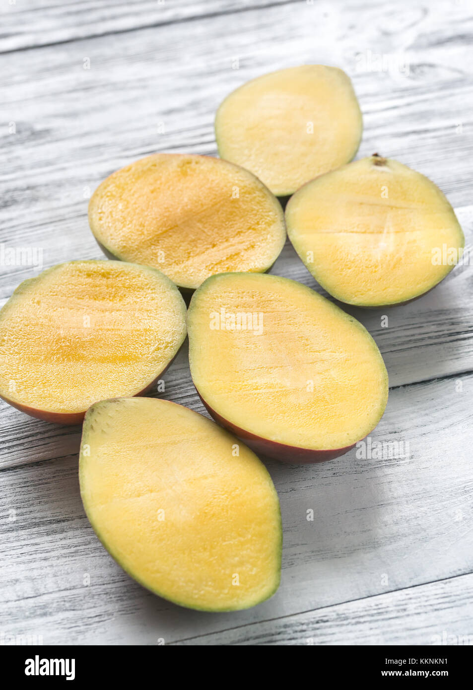 Halves of mango on the wooden background Stock Photo - Alamy