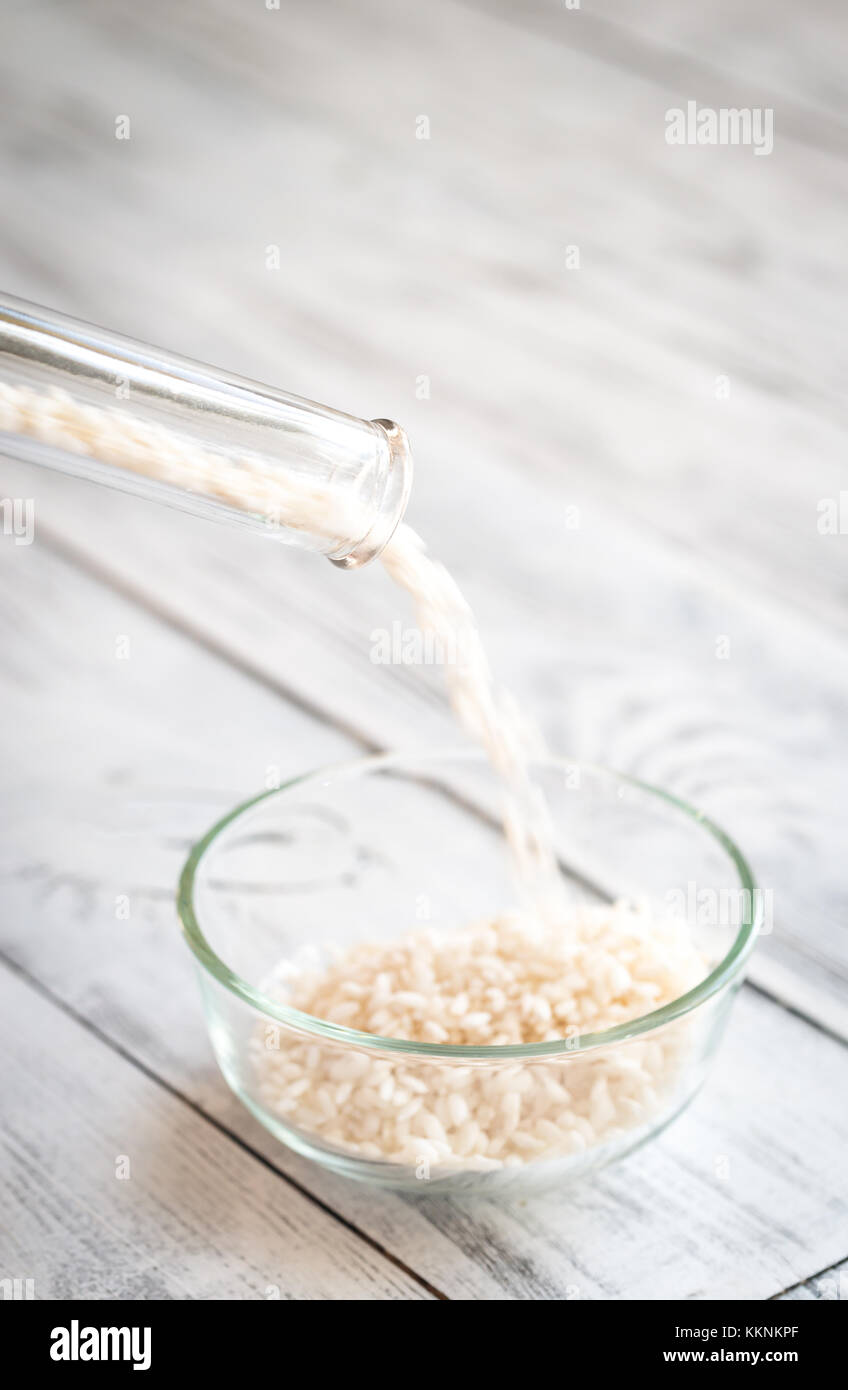 Pouring rice into glass bowl Stock Photo - Alamy