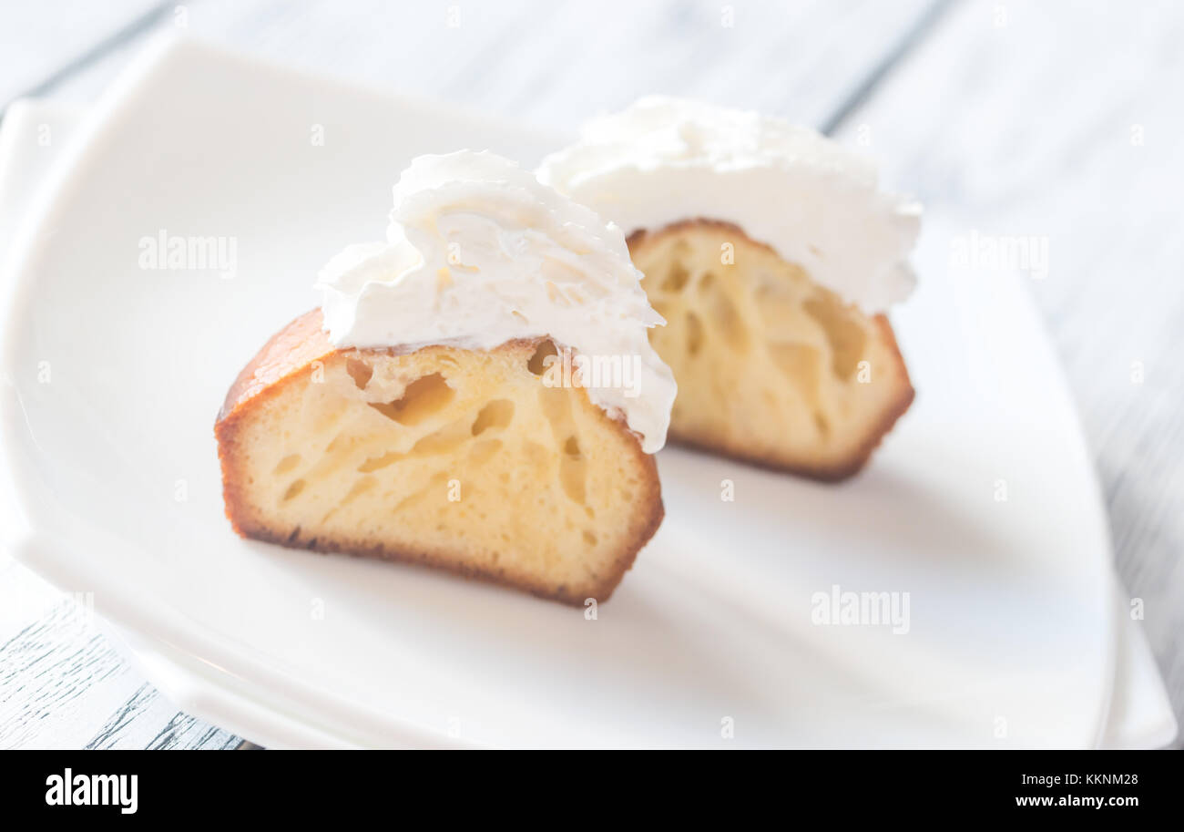 Rum baba decorated with whipped cream on the plate Stock Photo - Alamy