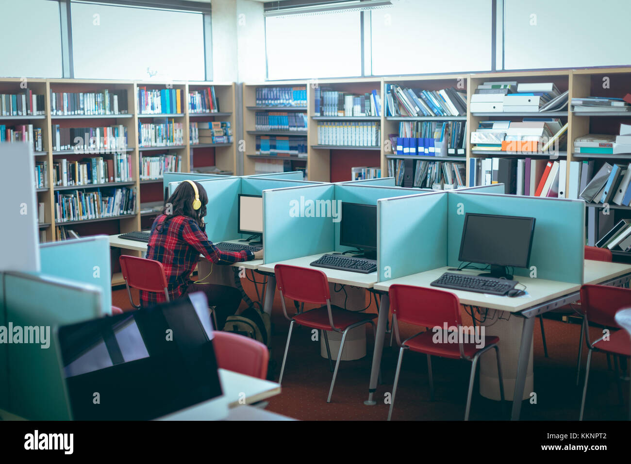 Girl using computer in library Stock Photo - Alamy