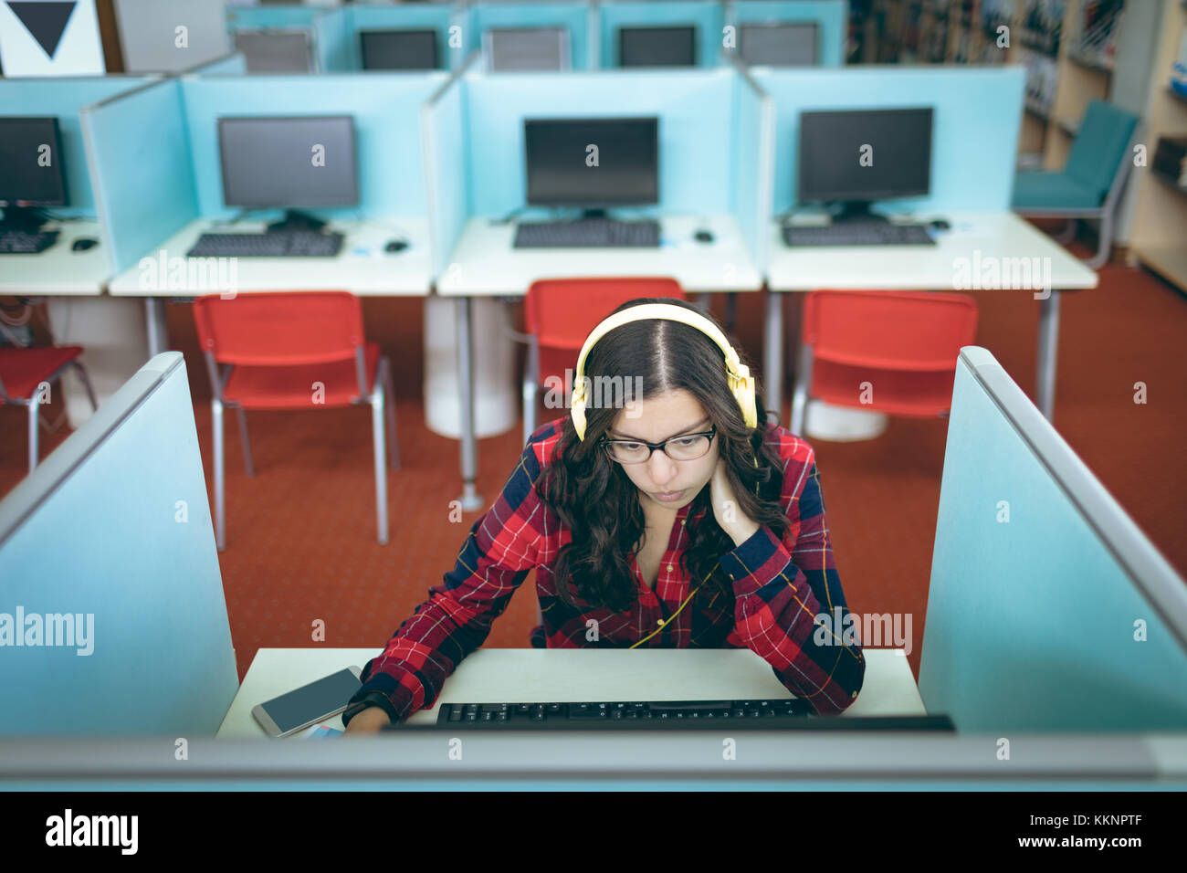 Girl using computer in library Stock Photo - Alamy