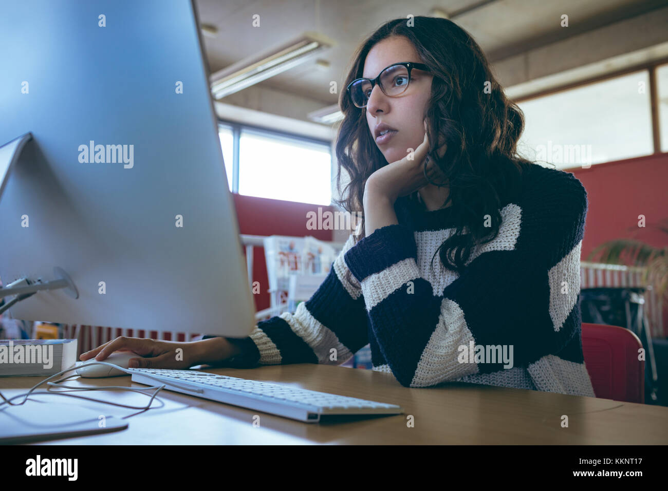 Girl using computer in library Stock Photo - Alamy