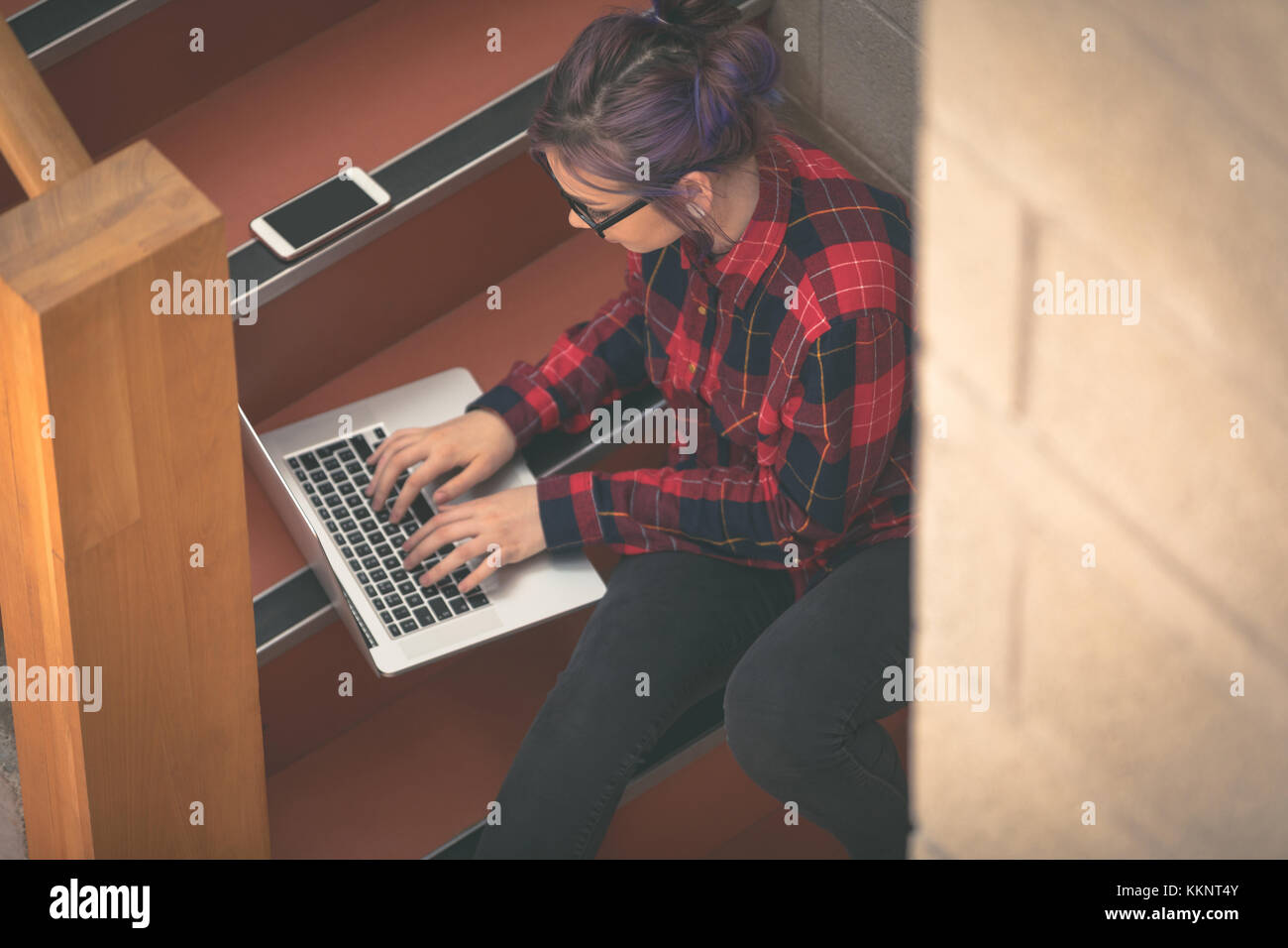 Girl using laptop in stairs Stock Photo - Alamy