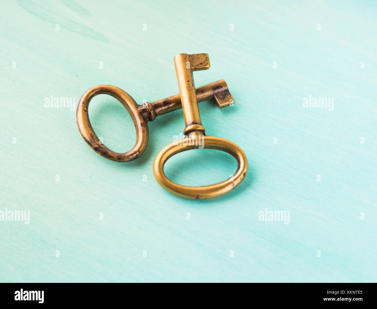 Two vintage brass keys on green pastel background Stock Photo - Alamy