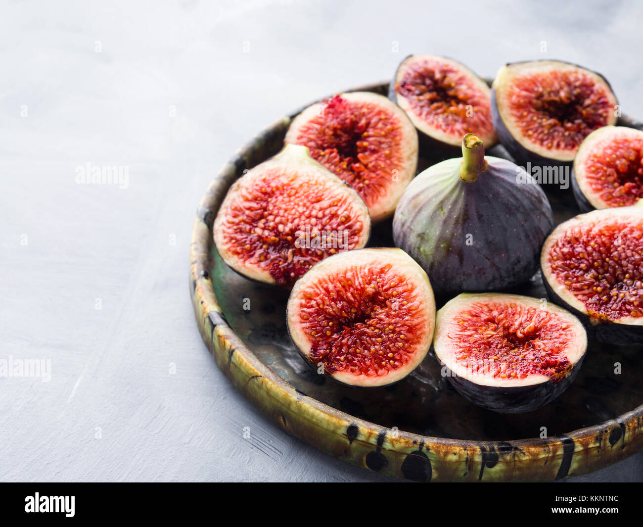 Dish of purple italian figs on gray background. Summer autumn fruit ...