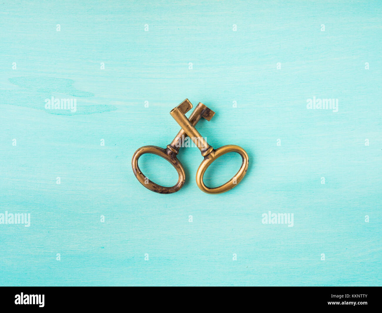 Two vintage brass keys on green pastel background Stock Photo - Alamy
