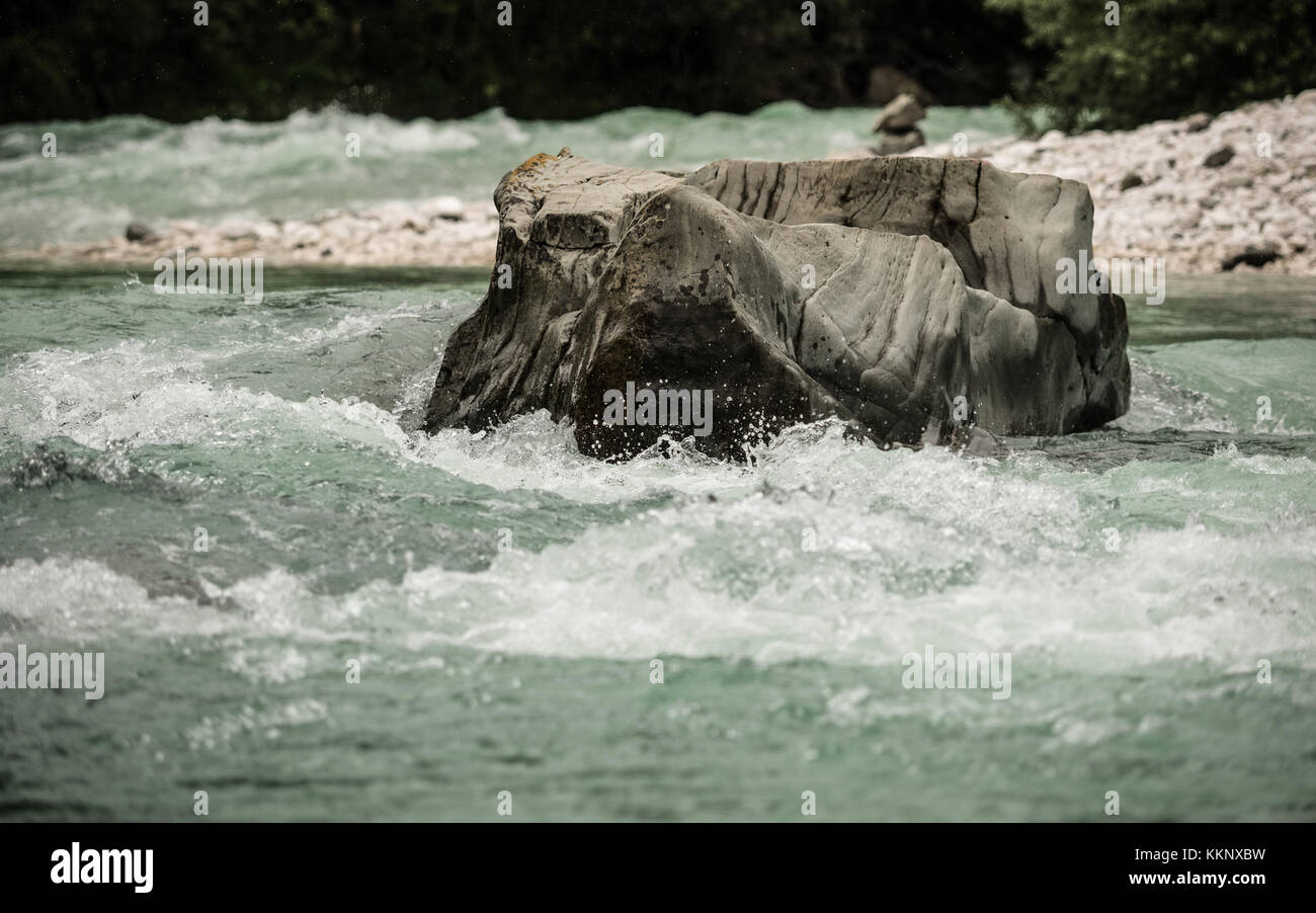 rock surrounded by a powerful stream Stock Photo - Alamy