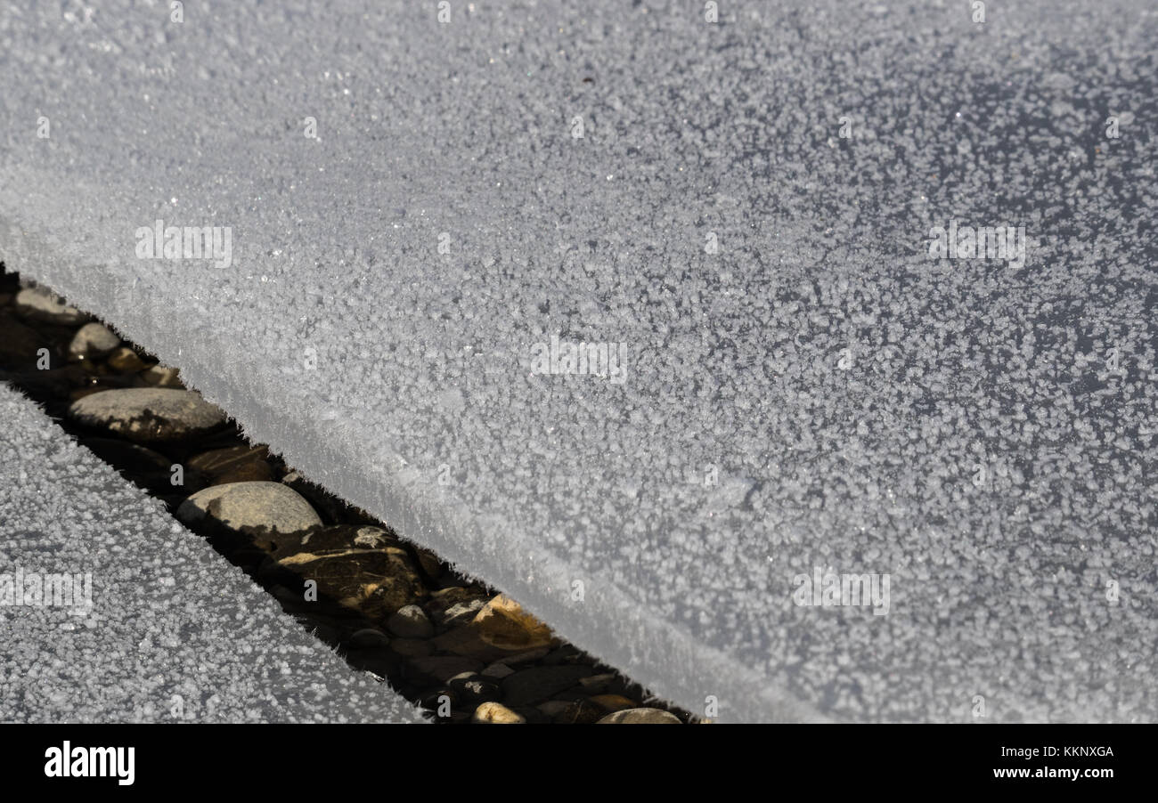 Small rocks under a layer of ice and snow Stock Photo - Alamy