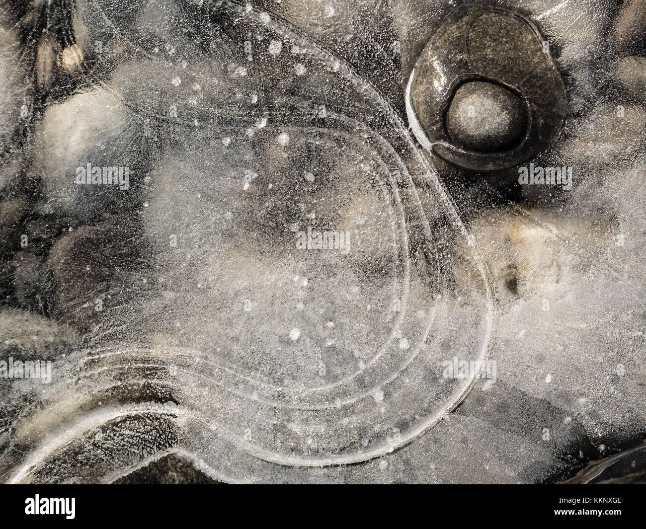 Small rock breaking through ice Stock Photo - Alamy