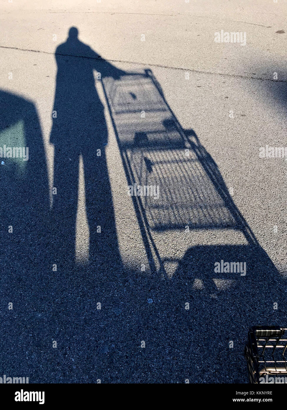 Shadow of man pushing shopping cart Stock Photo - Alamy