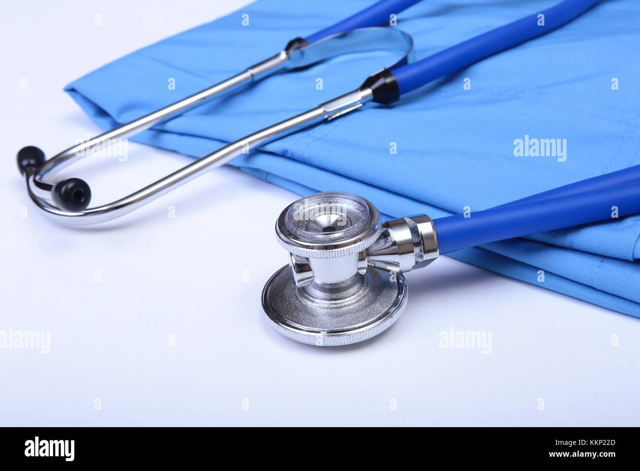 Medical stethoscope head lying on blue doctor uniform closeup. Medical ...