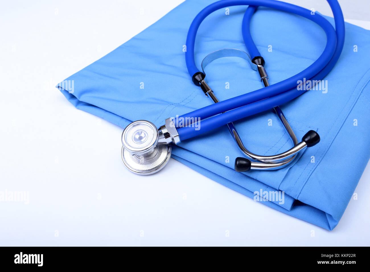 Medical stethoscope head lying on blue doctor uniform closeup. Medical ...