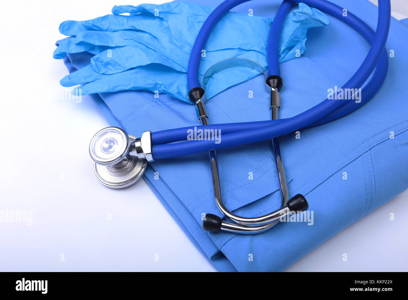 Medical stethoscope head lying on blue doctor uniform closeup. Medical ...