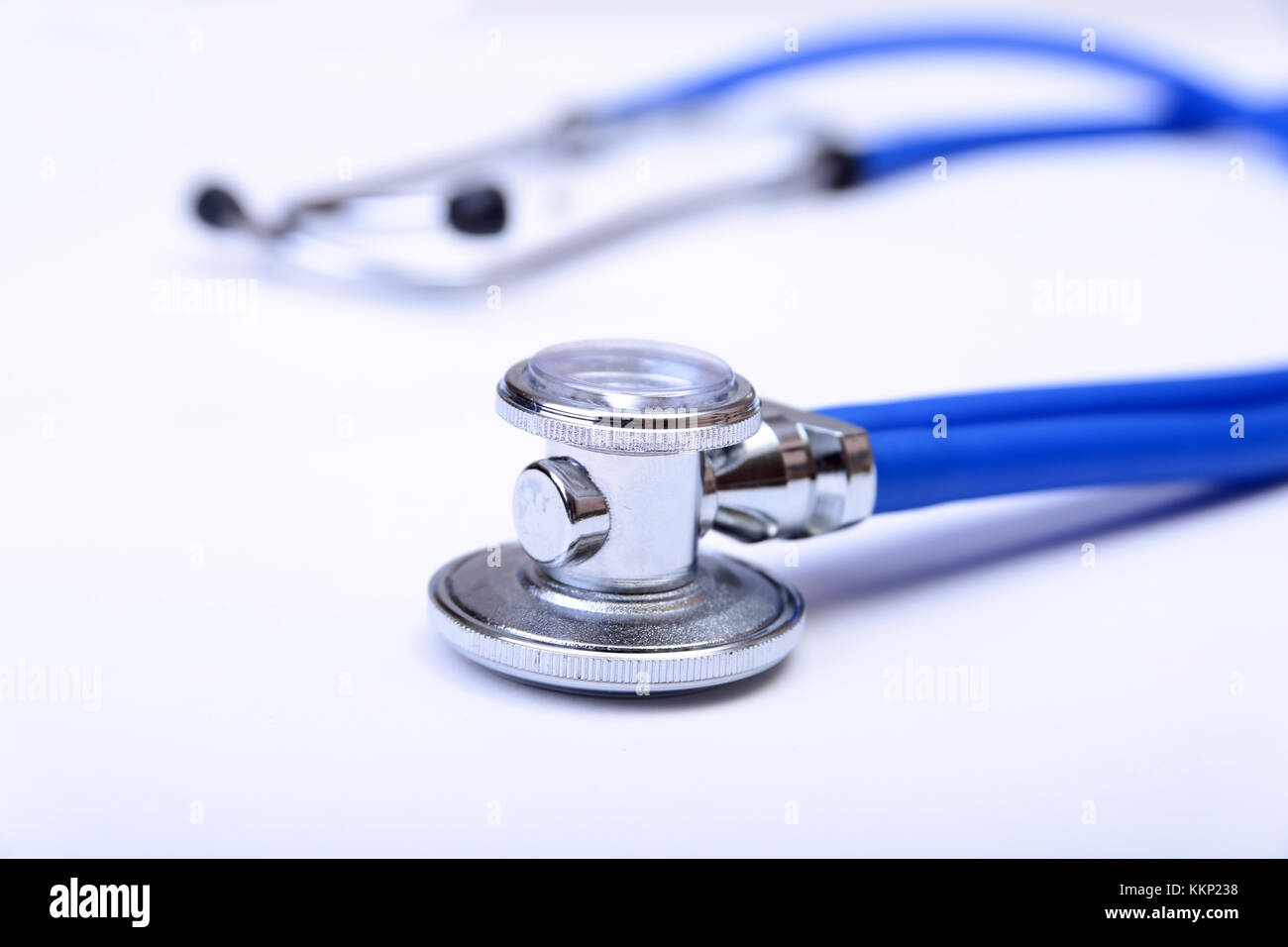 Medical stethoscope head lying on blue doctor uniform closeup. Medical ...