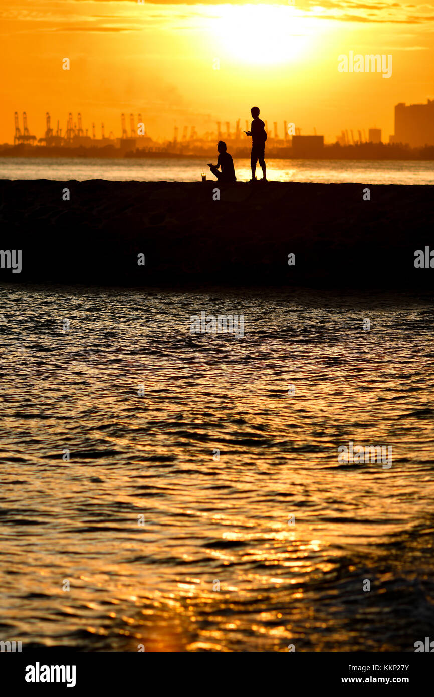 Golden sunset by the sea with friends Stock Photo - Alamy