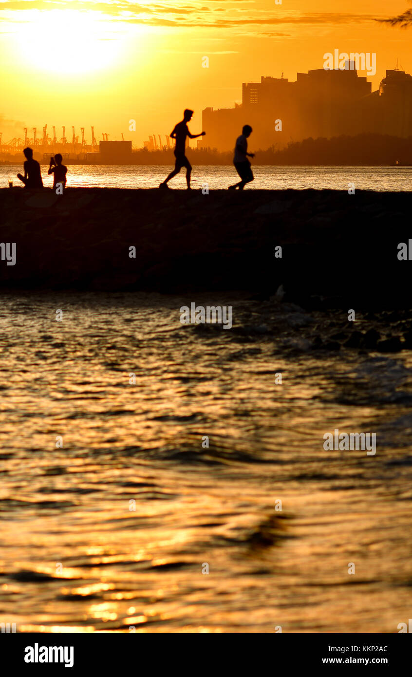 Golden sunset by the sea with friends Stock Photo - Alamy
