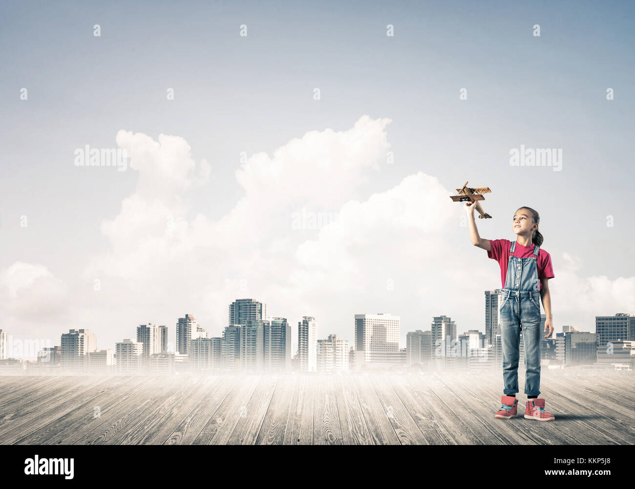 Cute kid girl standing on wooden floor with airplane Stock Photo - Alamy