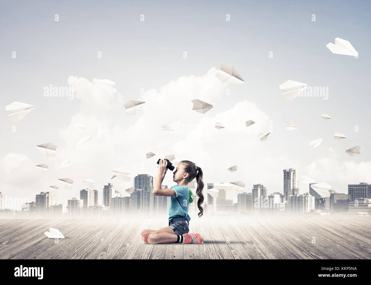 Cute kid girl sitting on wooden floor and paper planes flying around ...