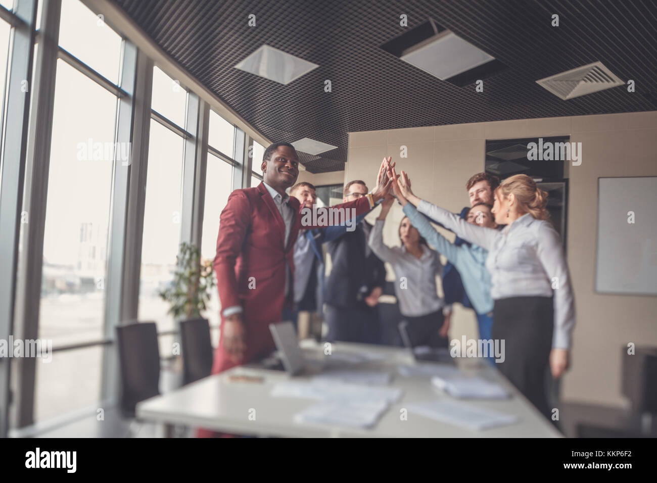 business team giving a high fives gesture as they laugh and cheer their ...
