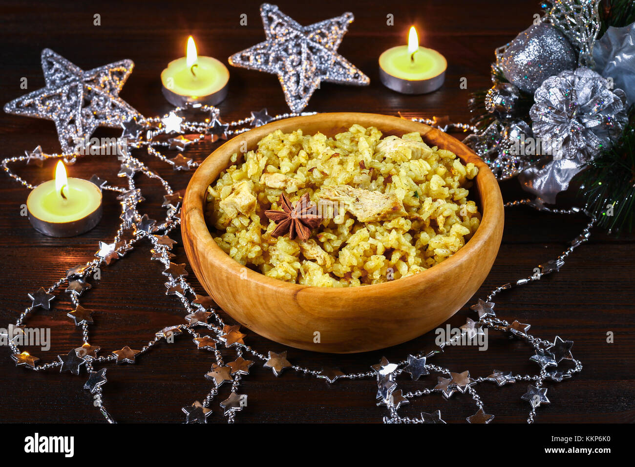 Indian biryani with chicken, yogurt and spices in a plate on a wooden ...