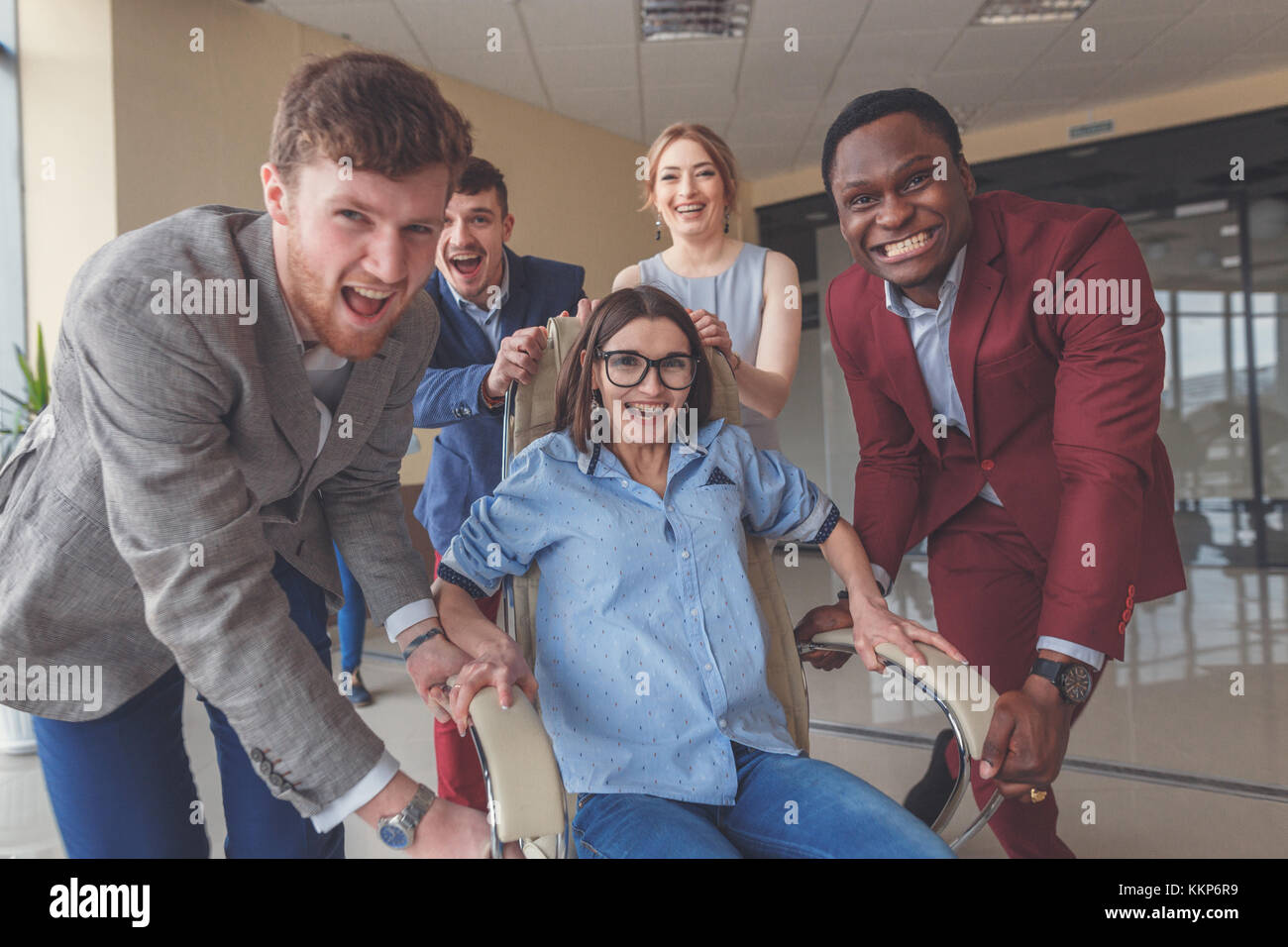 Successful excited Business people group team push colleague sitting in ...