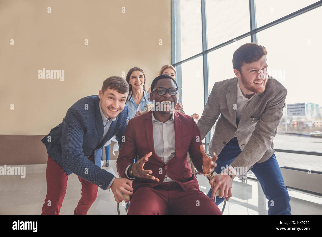 Successful excited Business people group team push colleague sitting in ...