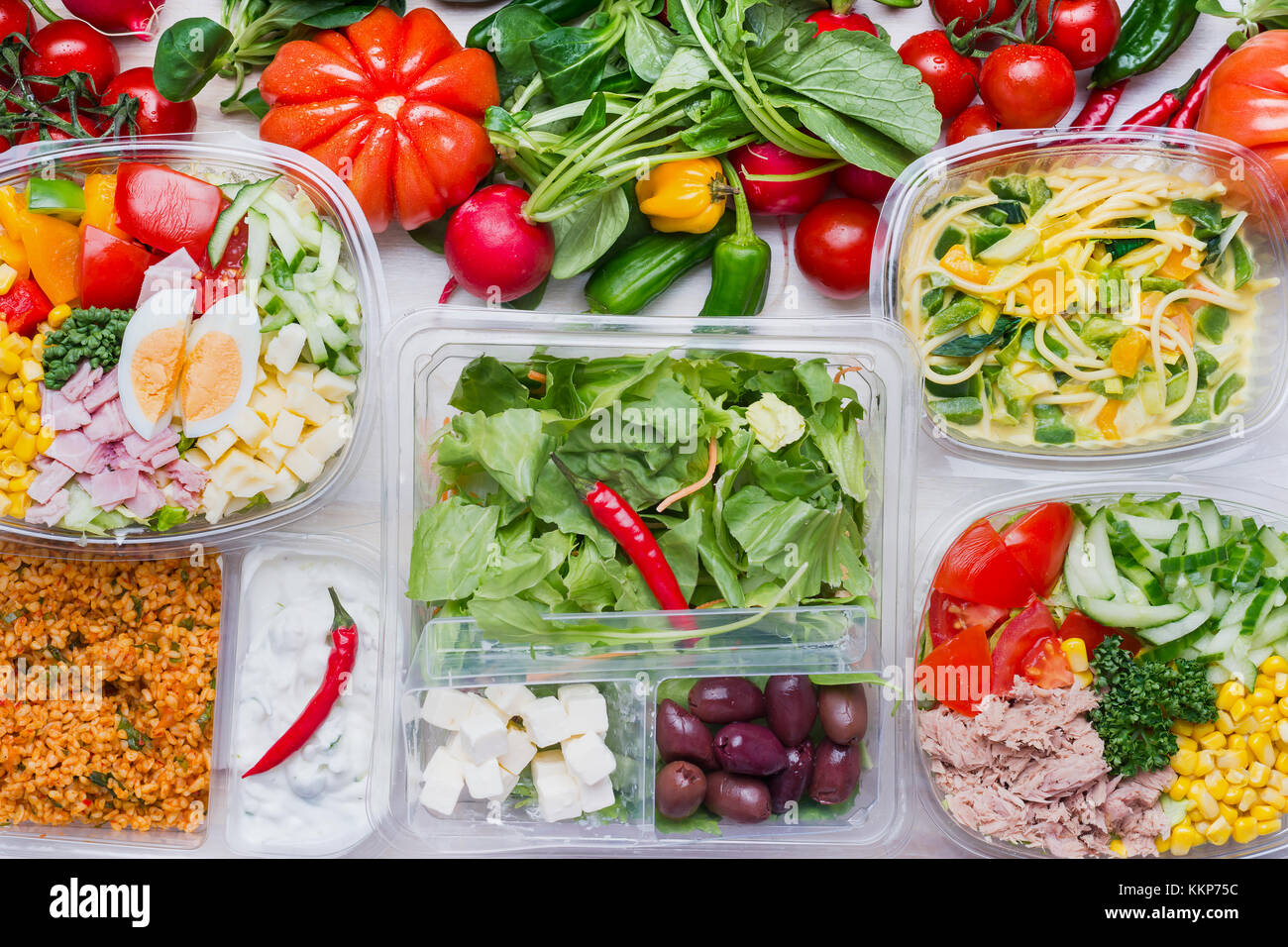Various healthy salad in plastic packages for diet lunch, top view ...