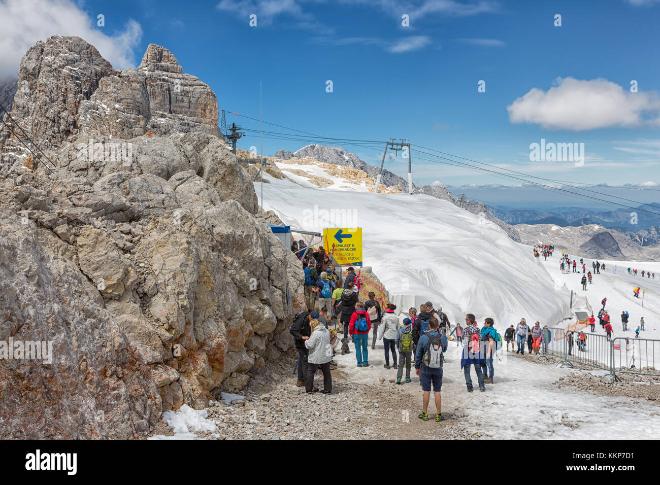 Dachstein glacier with people entering rope bridge between two ...