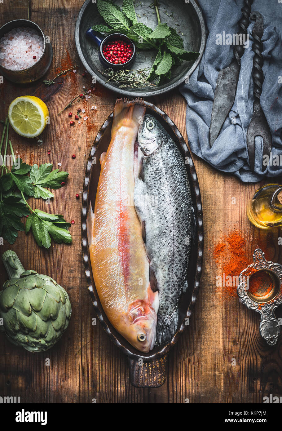 Fish dish cooking preparation. Two Trout fishes in baking form on ...