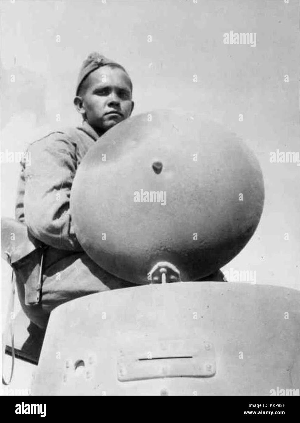 A historical photograph showing a boy gunner positioned on top of a ...