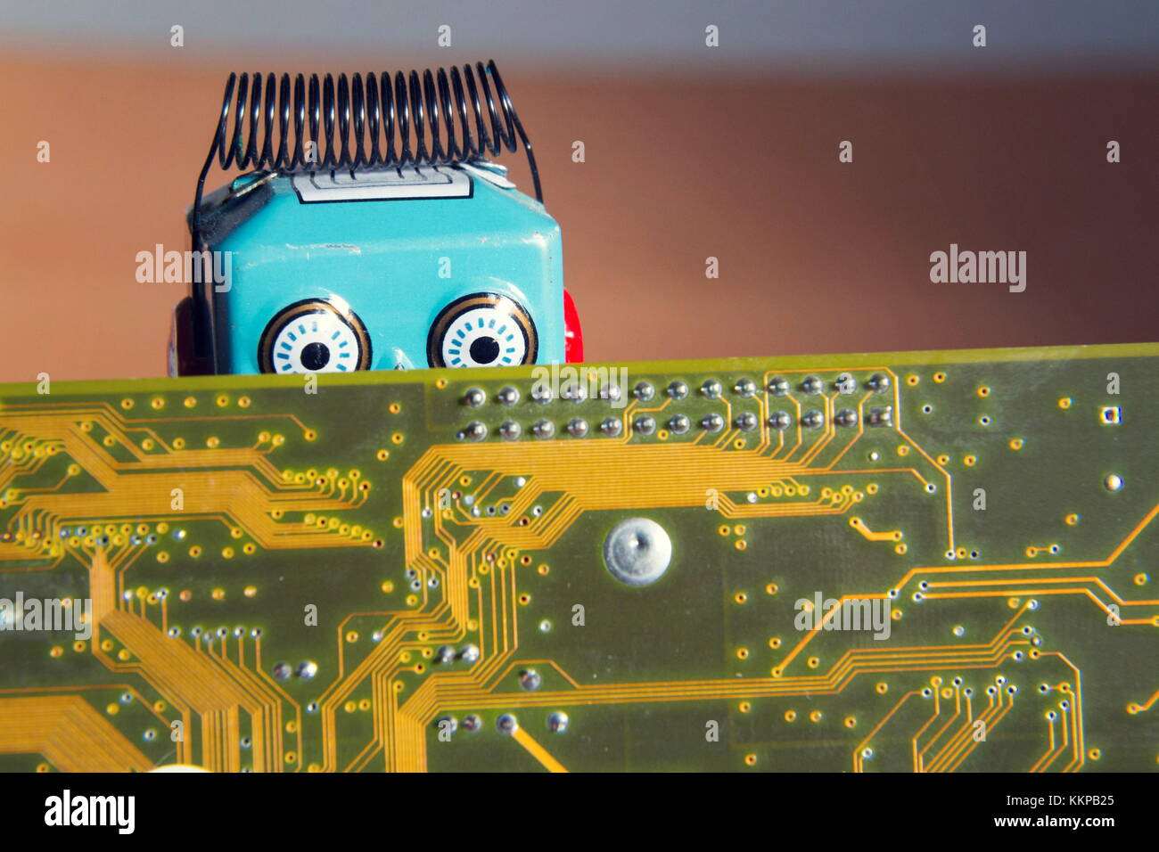 Vintage tin toy robot behind computer board, artificial intelligence ...