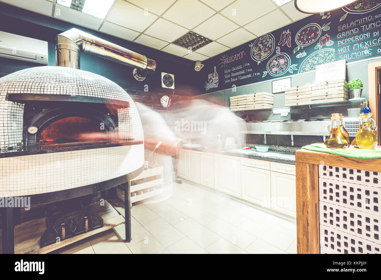 Fast moving pizzaioilo chef at local pizzeria by woddfired pizza oven ...