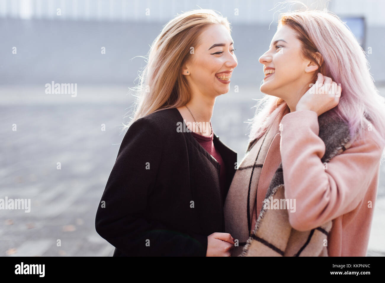 Two girls talking to each other and laughing, autumn clothing Stock ...