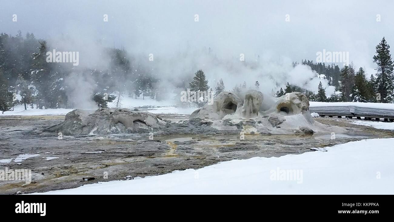 Snow and ice surround the Grotto Geyser in the Upper Geyser Basin at ...
