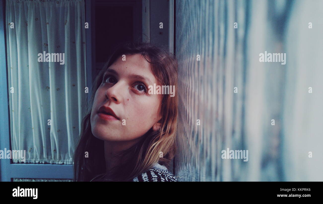 Young woman at home in front of a window Stock Photo - Alamy