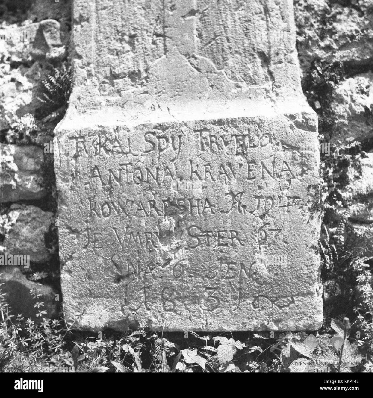 This image shows a detailed inscription on a gravestone near a church ...
