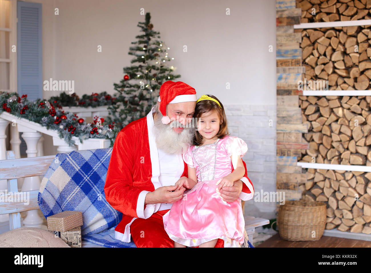 Father Christmas speaking with pretty girl dressed in pink frock and ...
