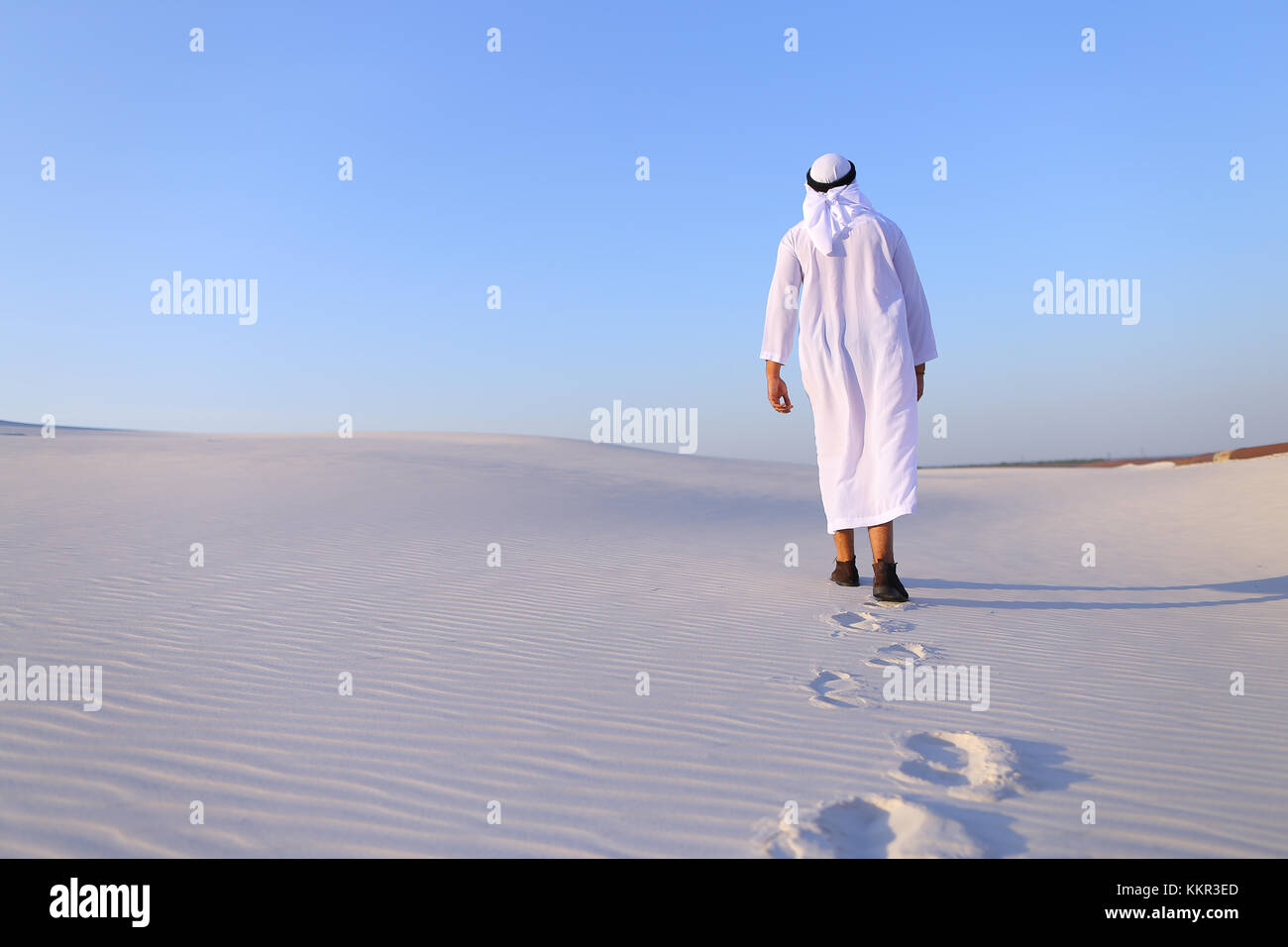 Confident Arabian tourist guy walks on foot along expanses of white ...